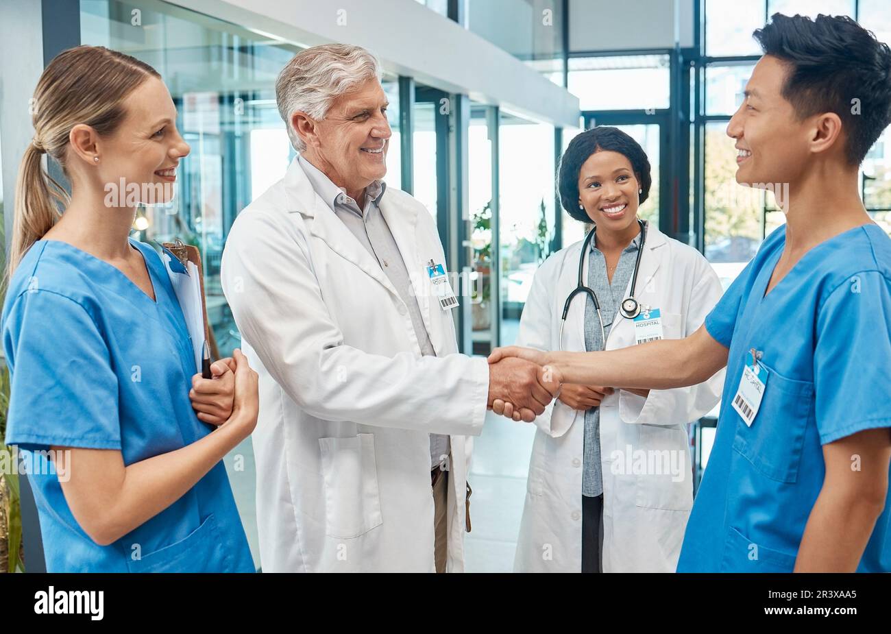 Healthcare, doctor and nurse shaking hands in a hospital to welcome or ...