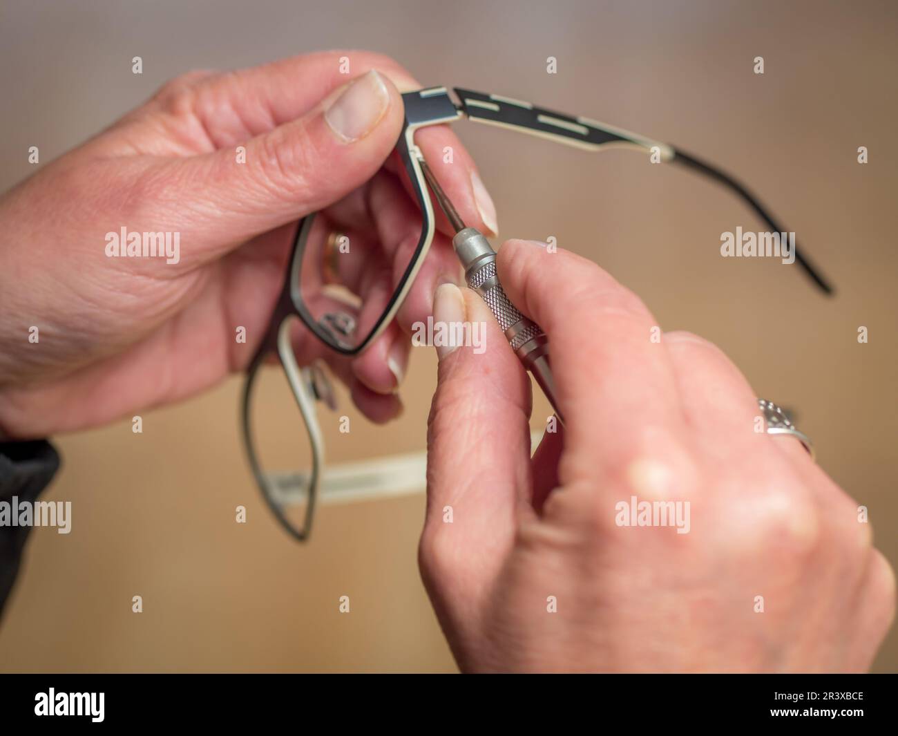 Optician preparing a pair of glasses. Tightening and adjusting of the ...
