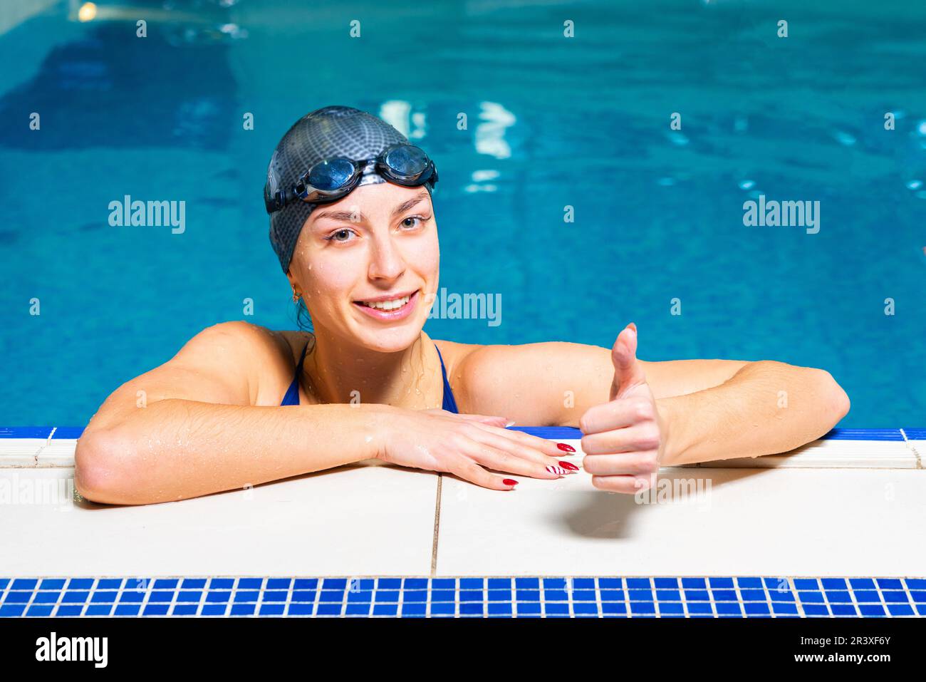 Young happy woman in swimming pool showing thumb up Stock Photo - Alamy