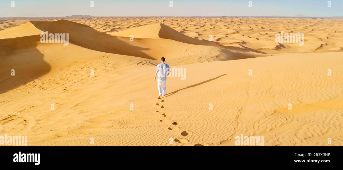 Young men walking in the desert of Dubai, Sand dunes of Dubai United ...