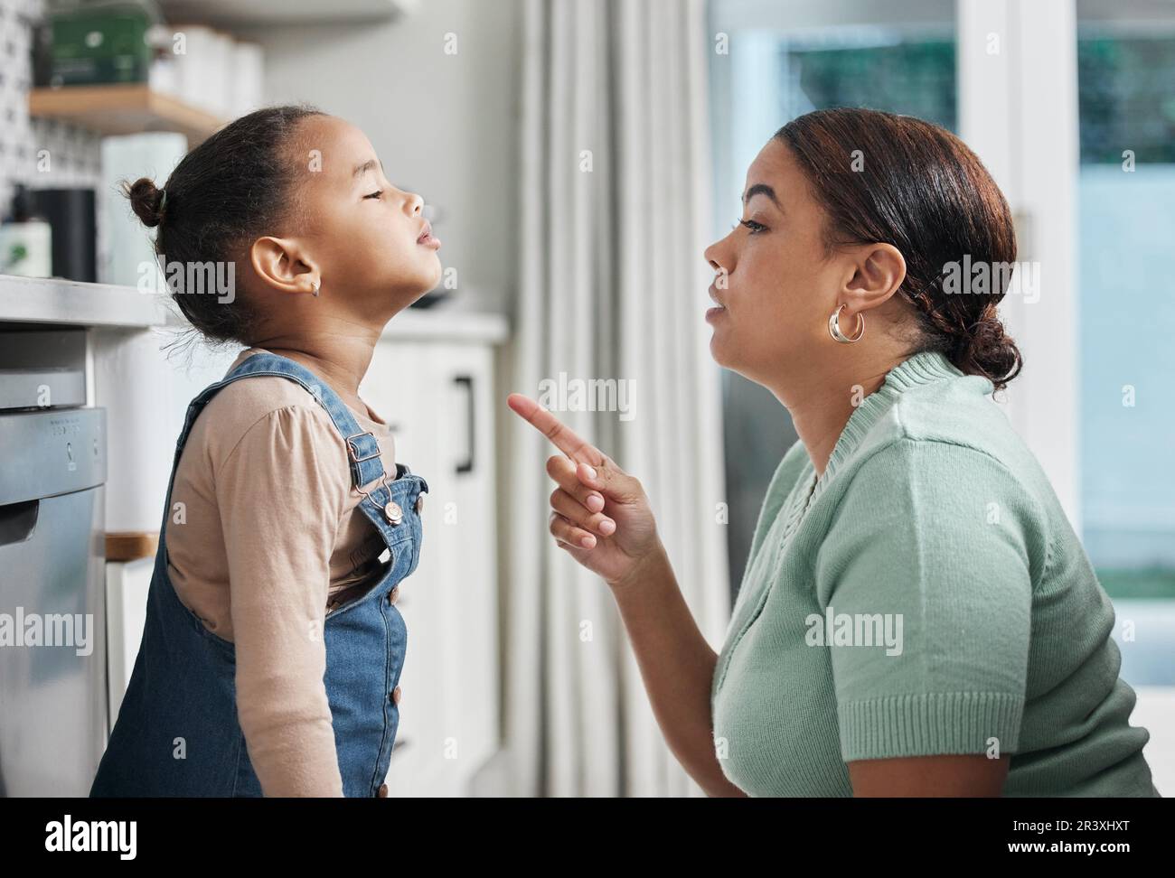 Conflict, mom talking and frustrated girl in kitchen, home or ...