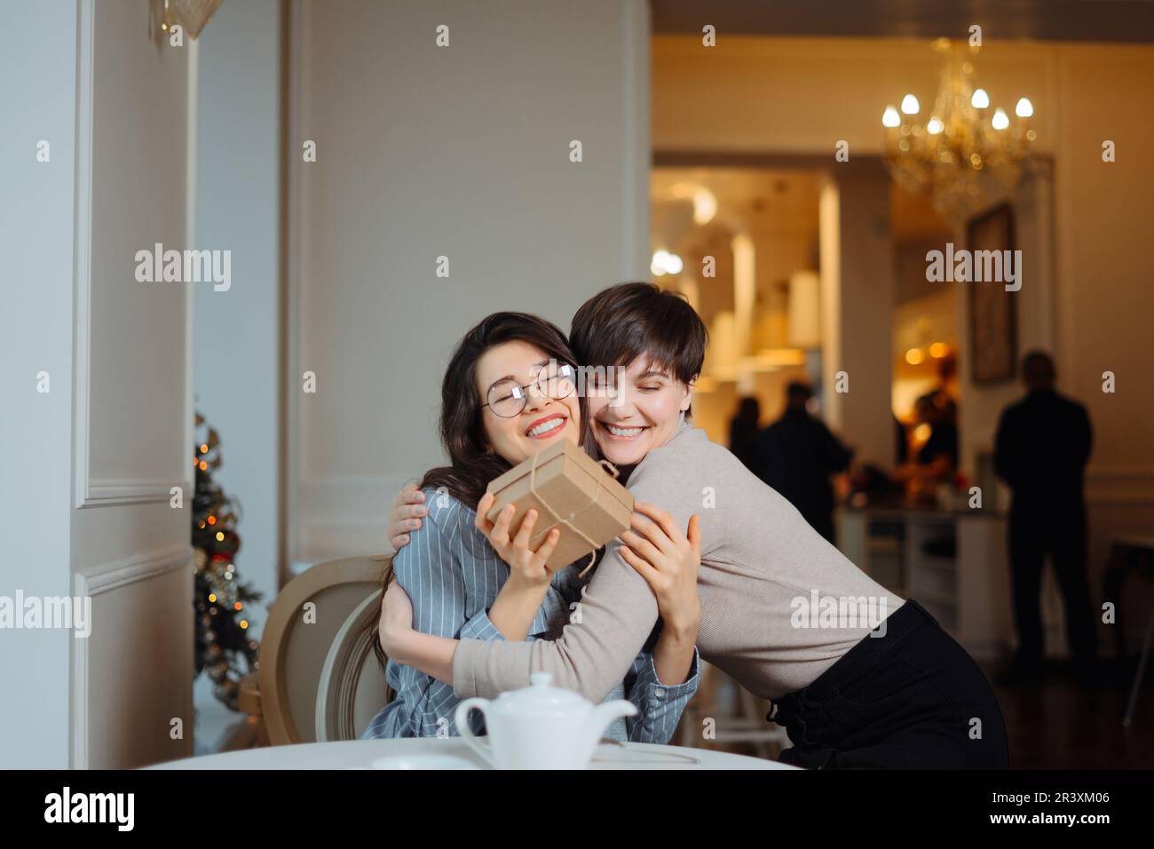 Young beautiful girl sitting in cafe with her friend and receiving a ...