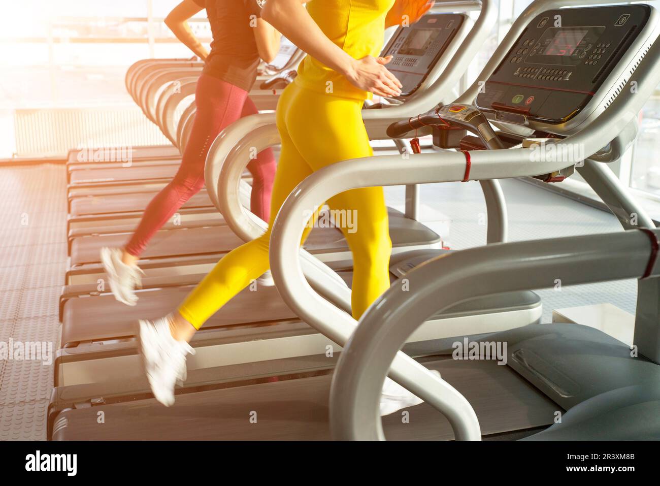 Two young women running on treadmill in gym Stock Photo - Alamy
