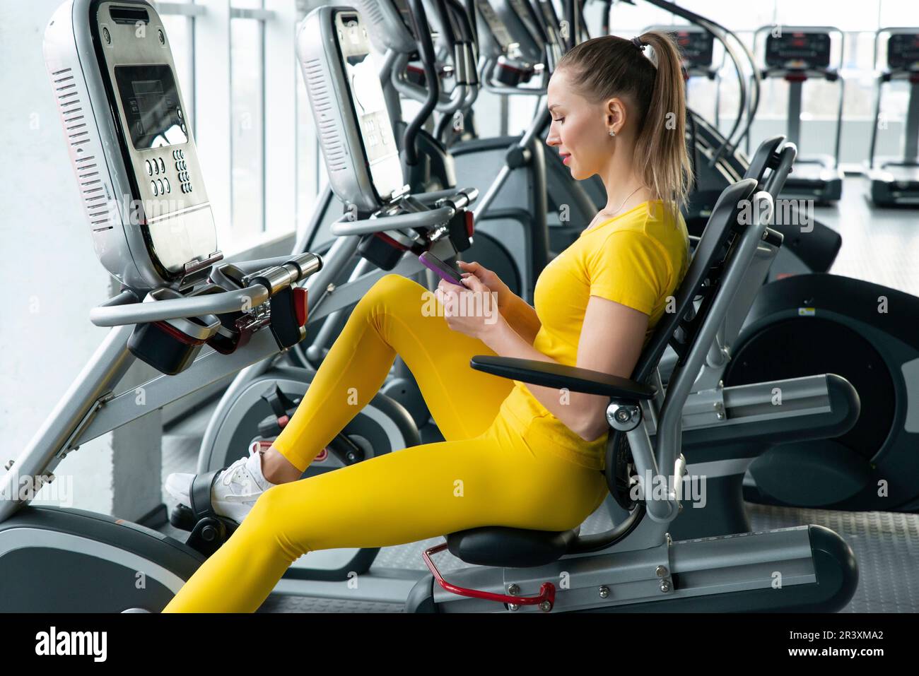 Woman on horizontal exercise bike in gym Stock Photo - Alamy