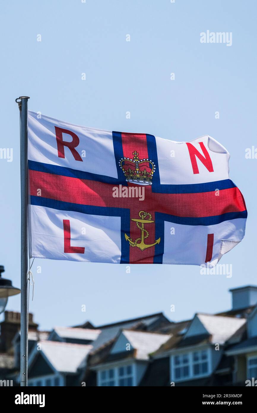 A RNLI flag fluttering on a flagpole in Newquay in Cornwall in the UK ...