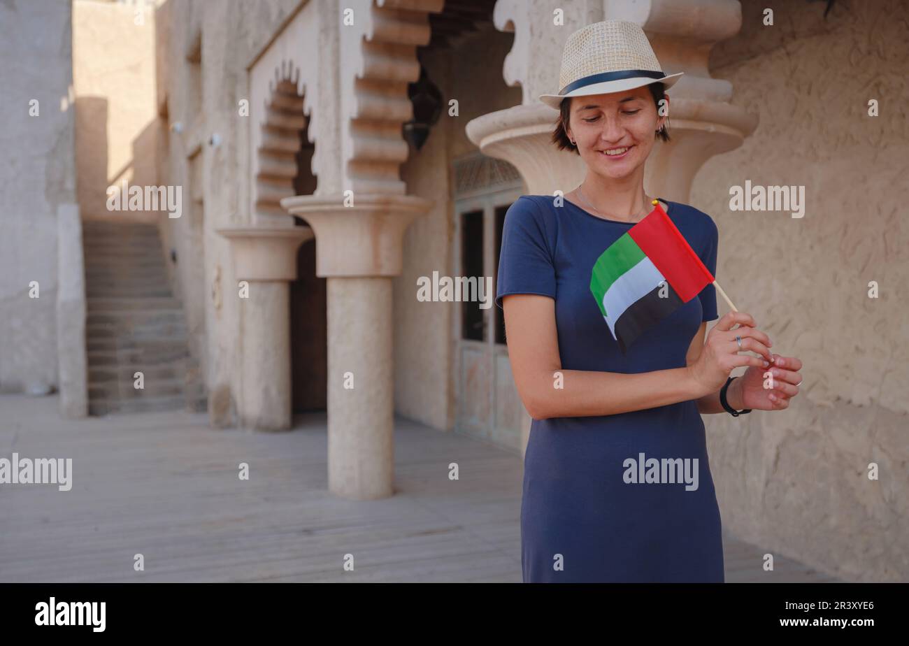 tourist trip to old Dubai, UAE. Asian Woman tourist holding UAE flag in ...
