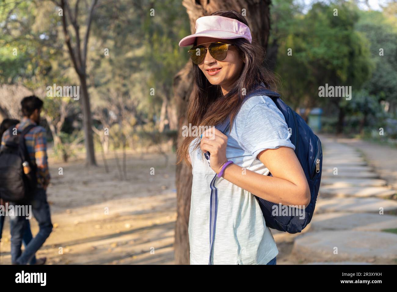 Young indian girl wearing sunglasses and cap backpack walking summer outdoor Stock Photo - Alamy