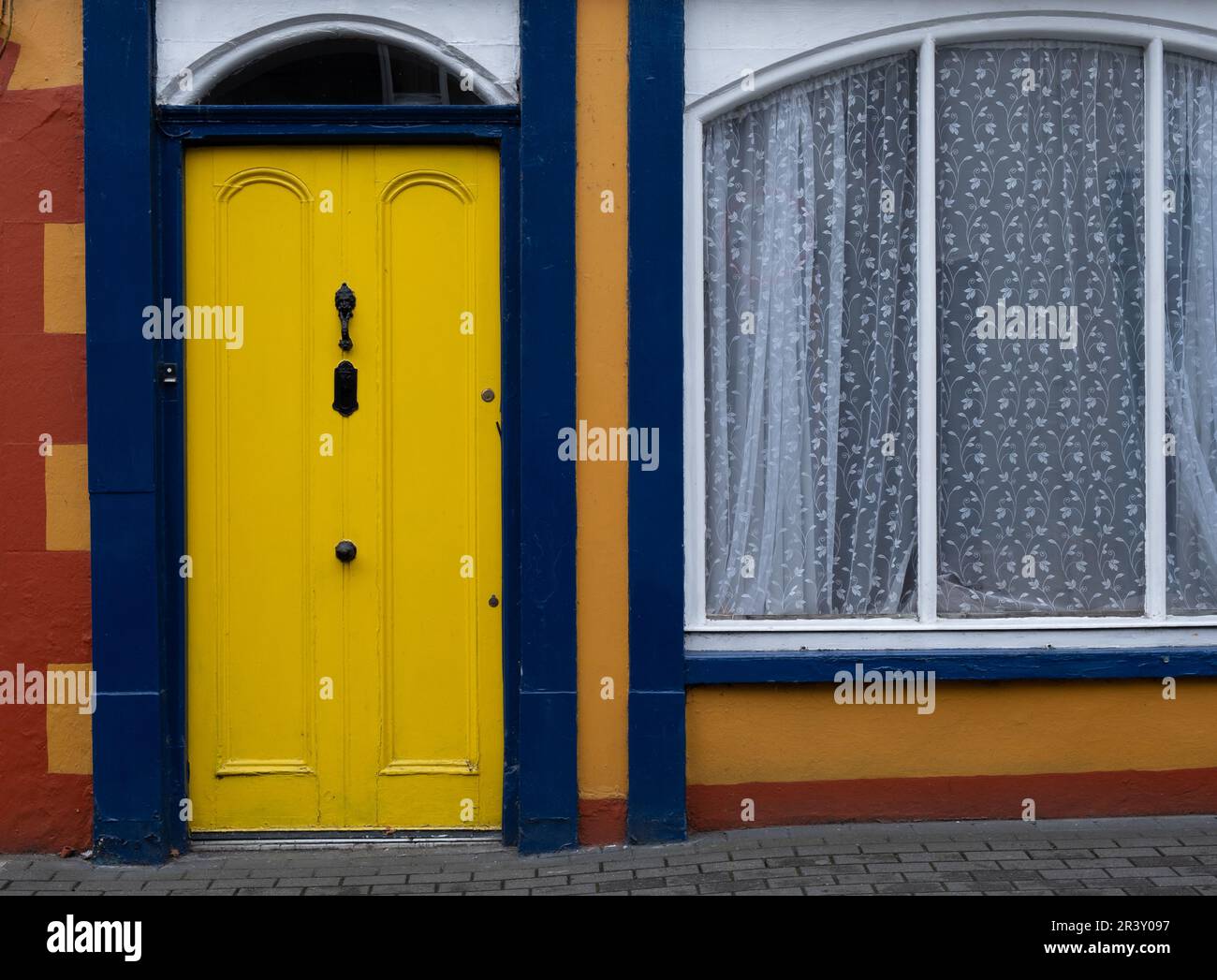 Traditional colourful house facade with closed window and door in ...