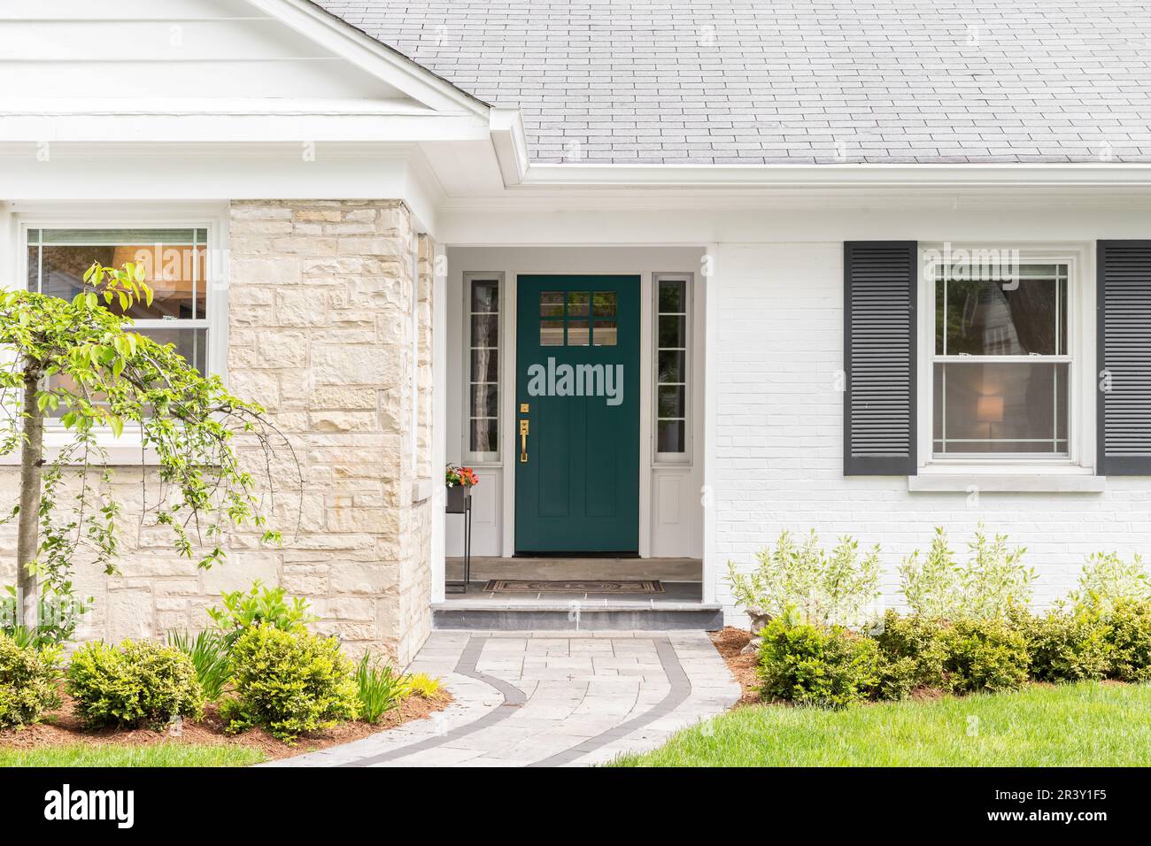 A detail of a front door on home with stone and white bricking siding ...