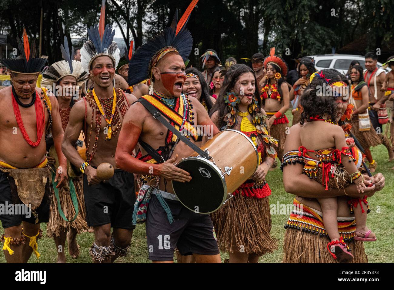 A group of indigenous people wearing ornaments dances and sings during ...