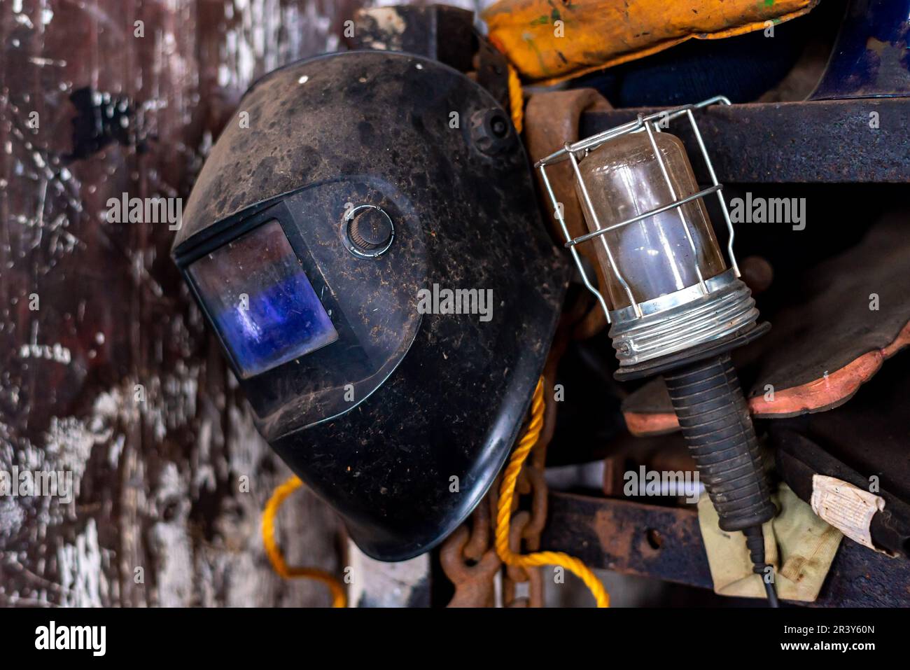Rubber hand light and welding helmet on a shelf Stock Photo - Alamy