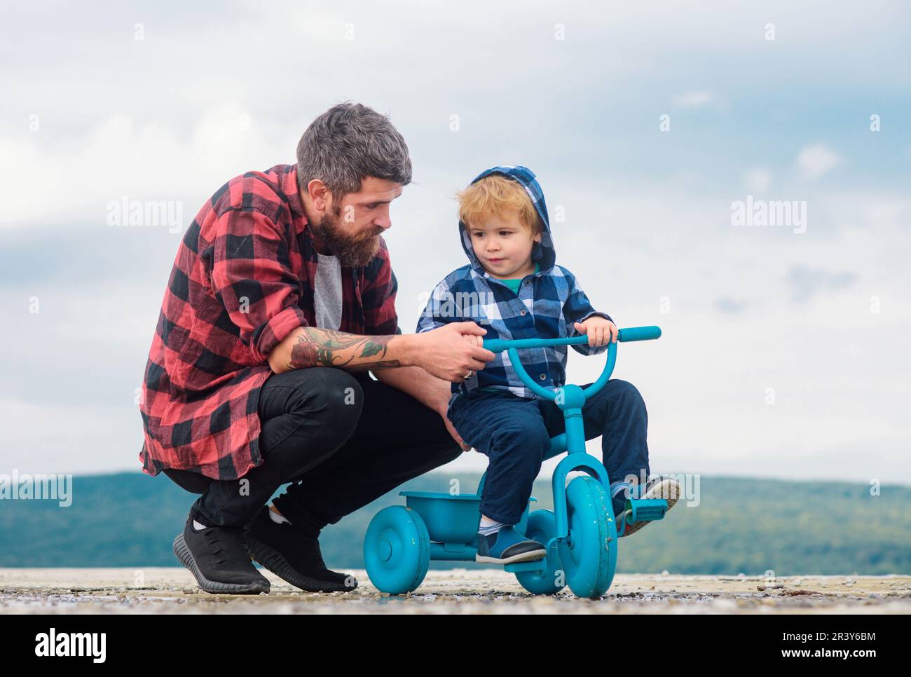 Father and son cycling with kids bike outdoor. cute Little boy learn to ...