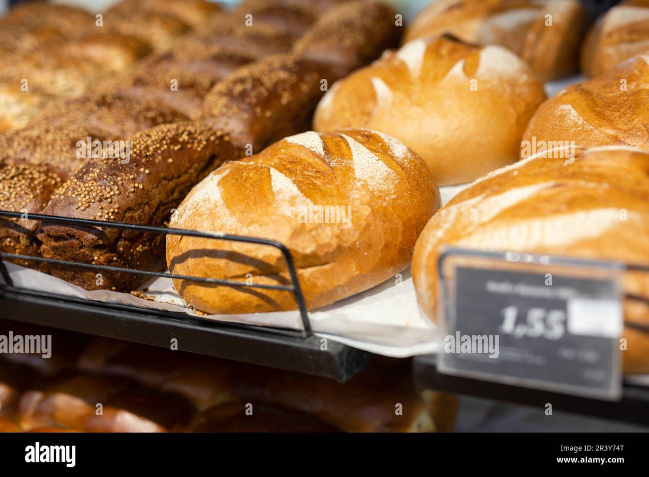 fresh golden breads on the shelf of the bread section of the ...