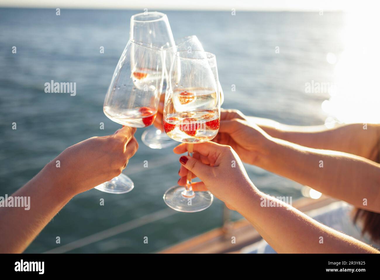 Sunset sky and sea on the background. Making a celebratory toast with ...