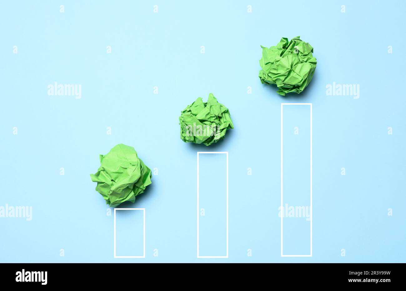 Crumpled sheets of green paper and a graph on a blue background ...