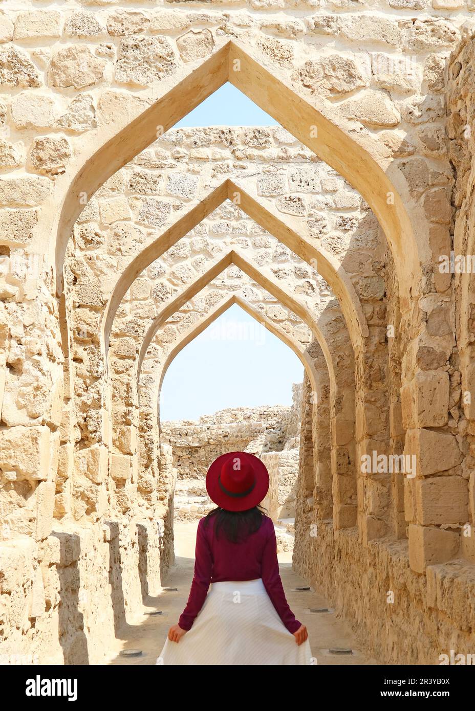 Female Visitor Walking Along the Iconic Archways of Qal'at al-Bahrain ...