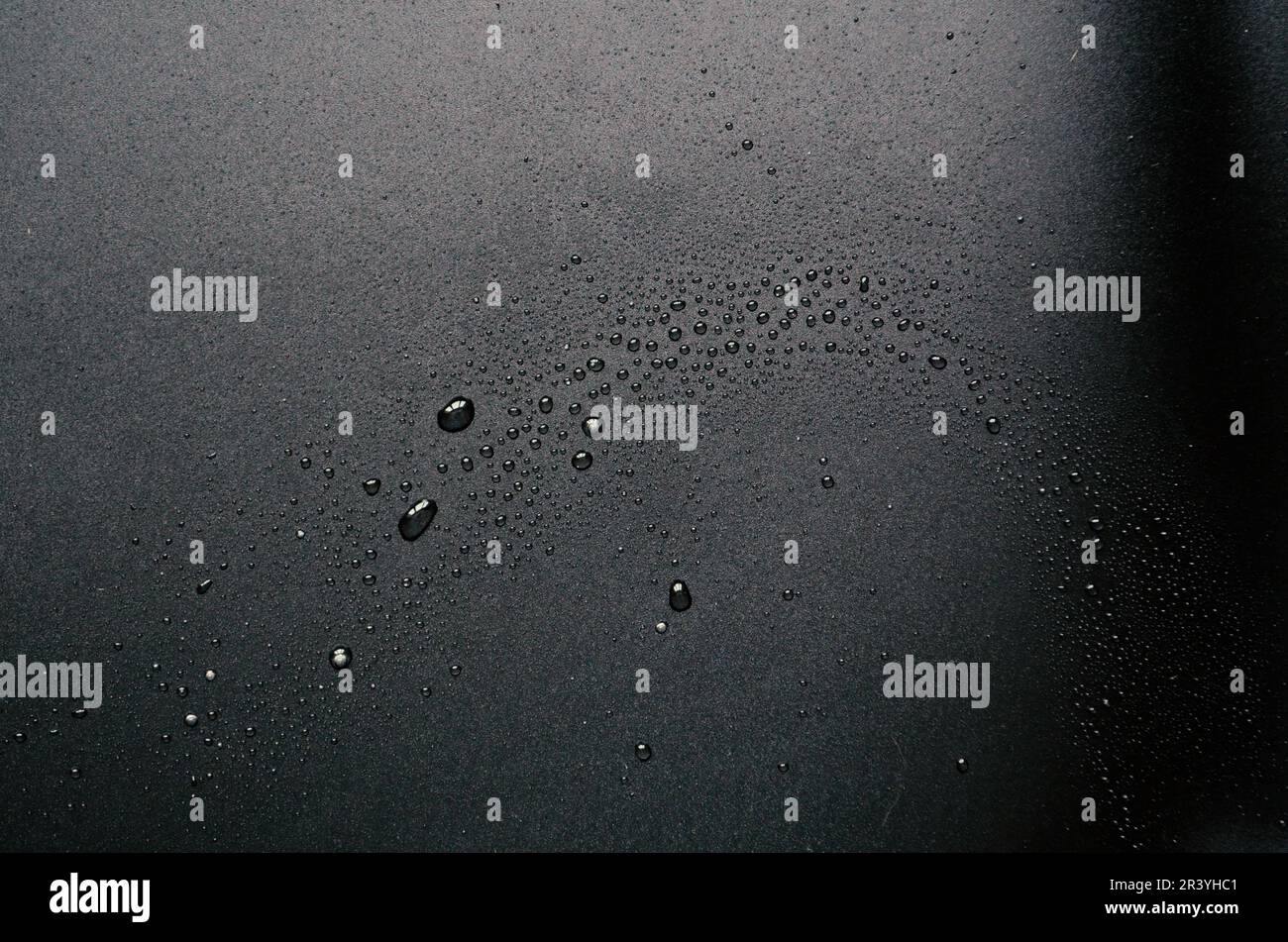 Drops of water on a dark matte surface close up, water blots, design ...