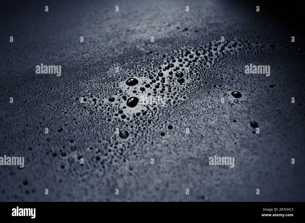 Drops of water on a dark matte surface close up, water blots, design ...