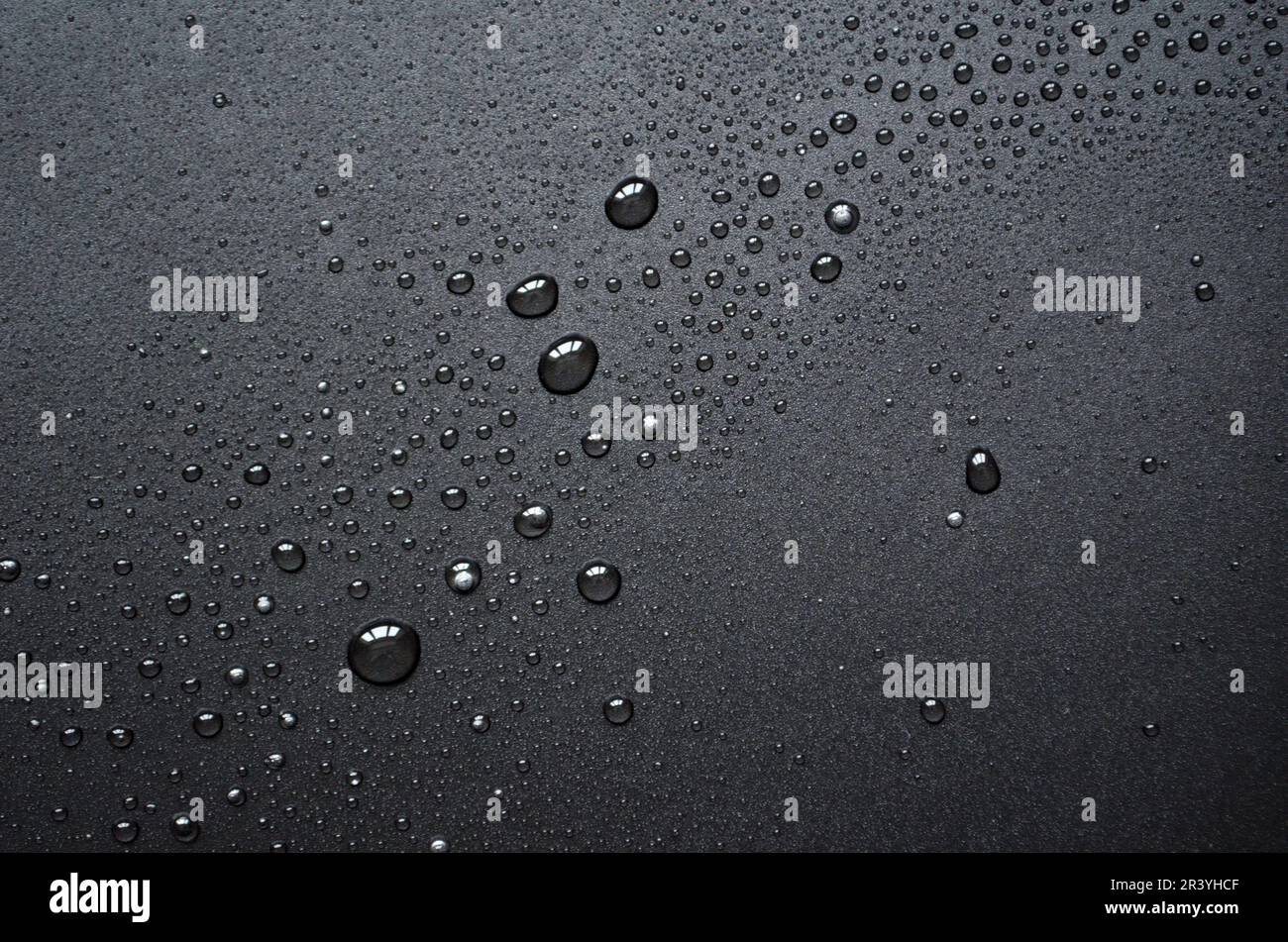 Drops of water on a dark matte surface close up, water blots, design ...