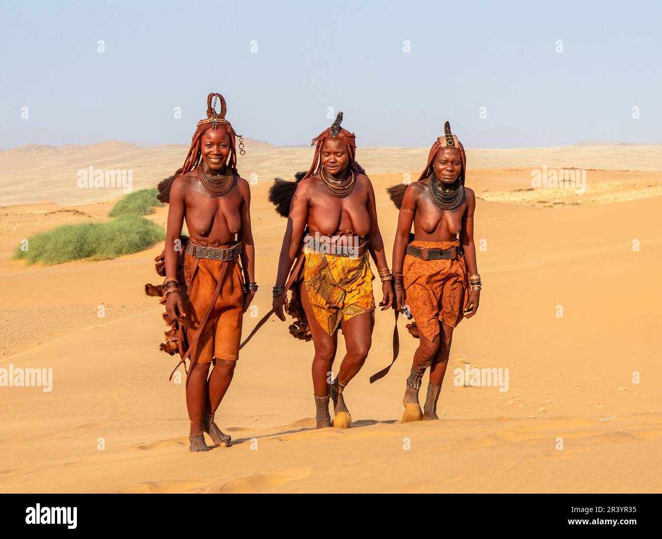 Three women of the Himba tribe in traditional dress walk in the desert Stock Photo - Alamy