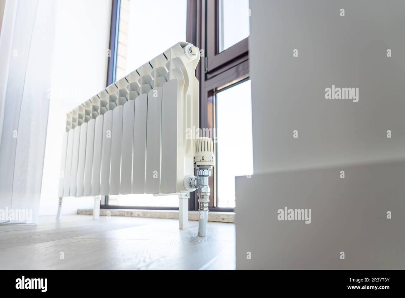 White big radiator near window in modern room Stock Photo - Alamy