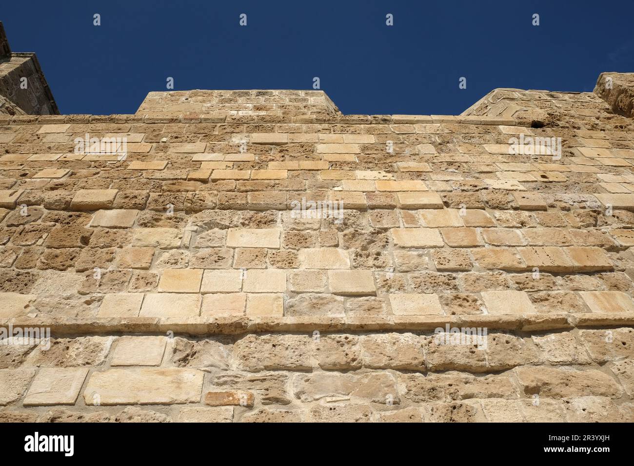 Top section of antique castle wall of old high sandy limestone to the ...
