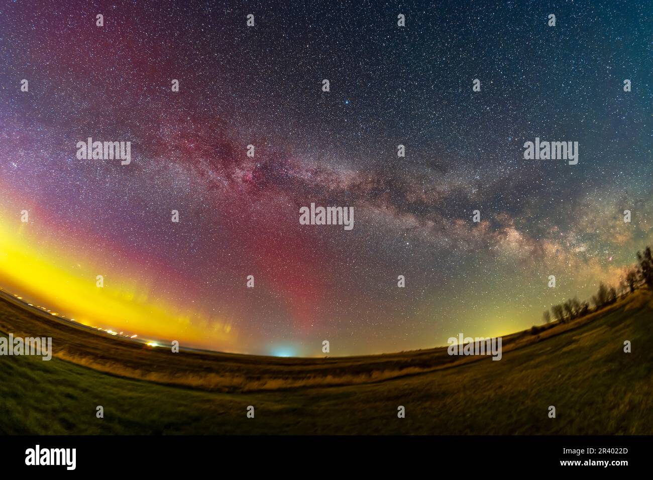 An auroral arc at left across the northern horizon with the summer ...