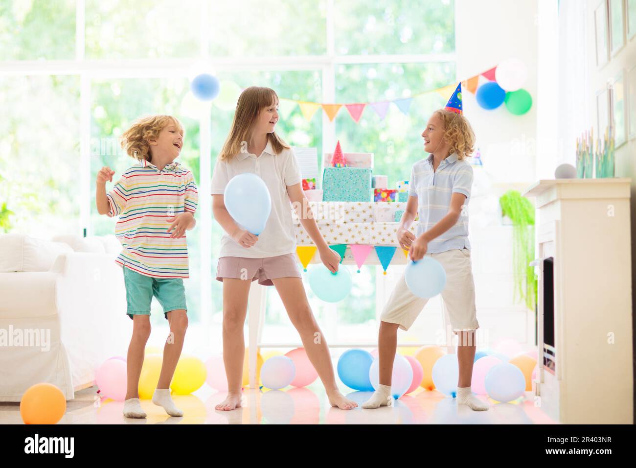 Kids birthday party. Children play with balloons and open presents ...