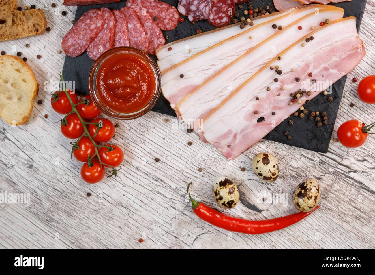 Antipasti different types of sausages and lard on a graphite board .Top ...