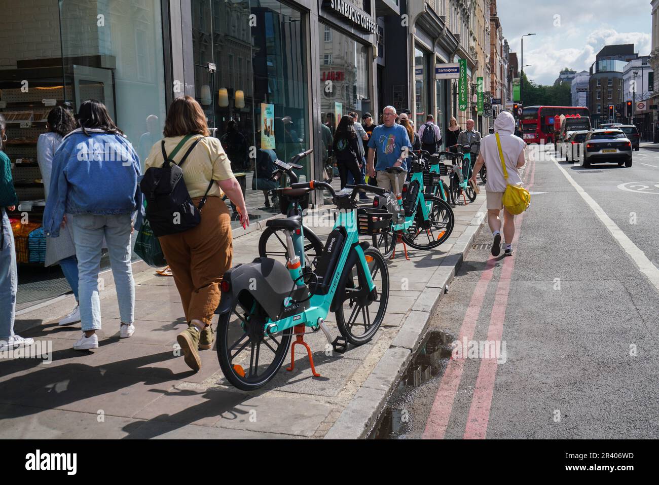 London UK. 25 May 2023 Pedestrians walk past Tier hire bikes in King's ...