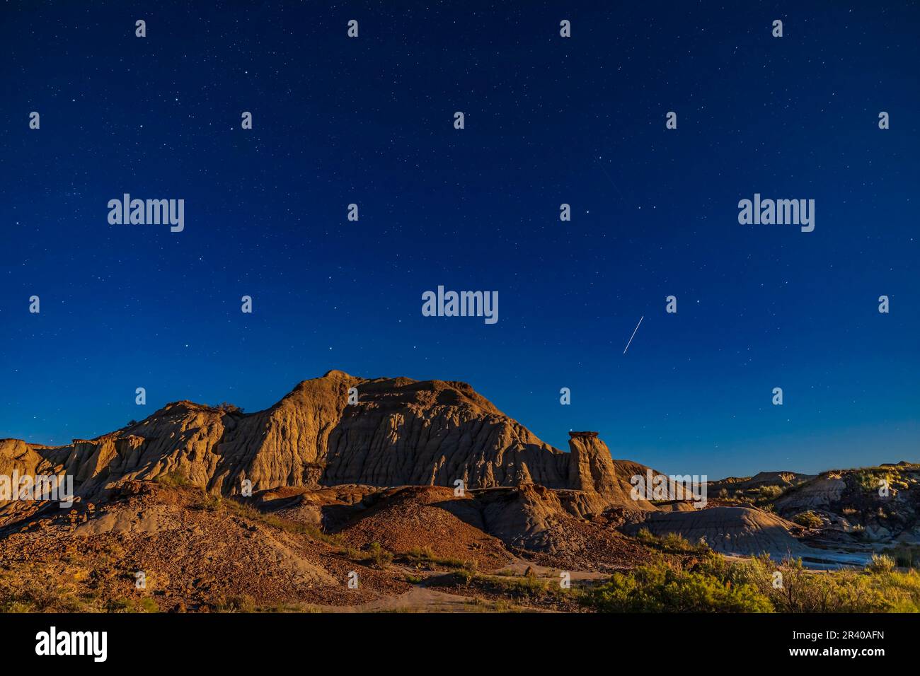 The International Space Station flying over the moonlit badlands ...