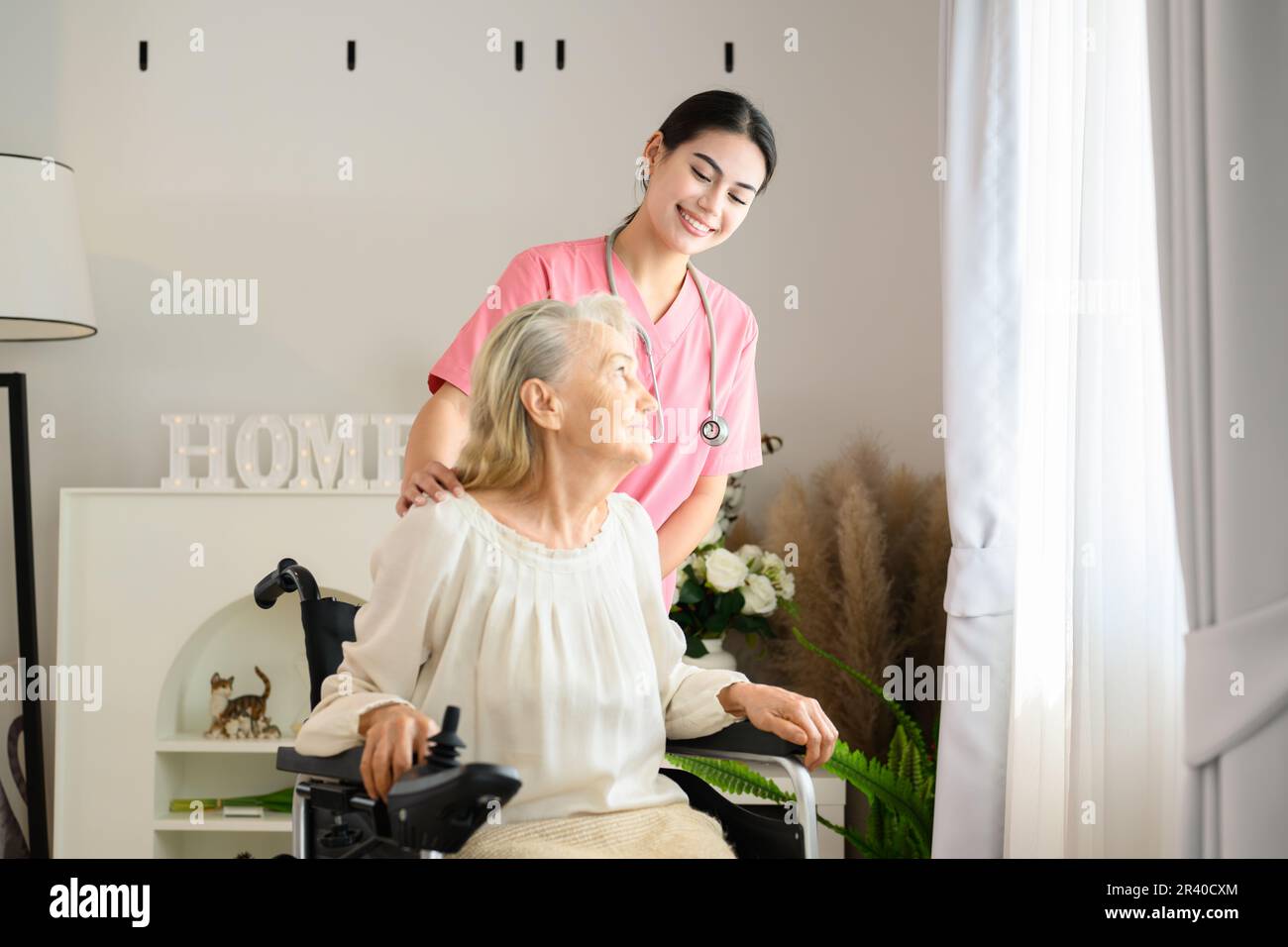Happy doctor talking with elderly patient at home visit Stock Photo - Alamy