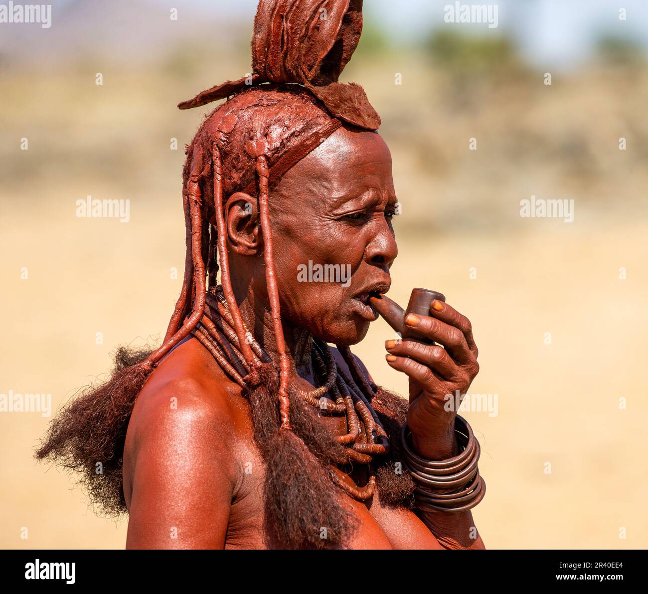 Portrait Of An Old Woman Of The Himba Tribe With A Smoking Pipe In Her