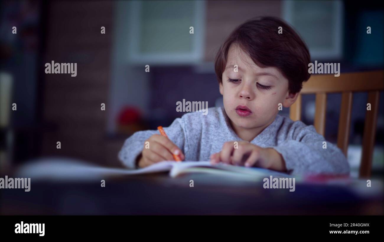 Little boy drawing with color pencil. Boy draws a picture at table ...