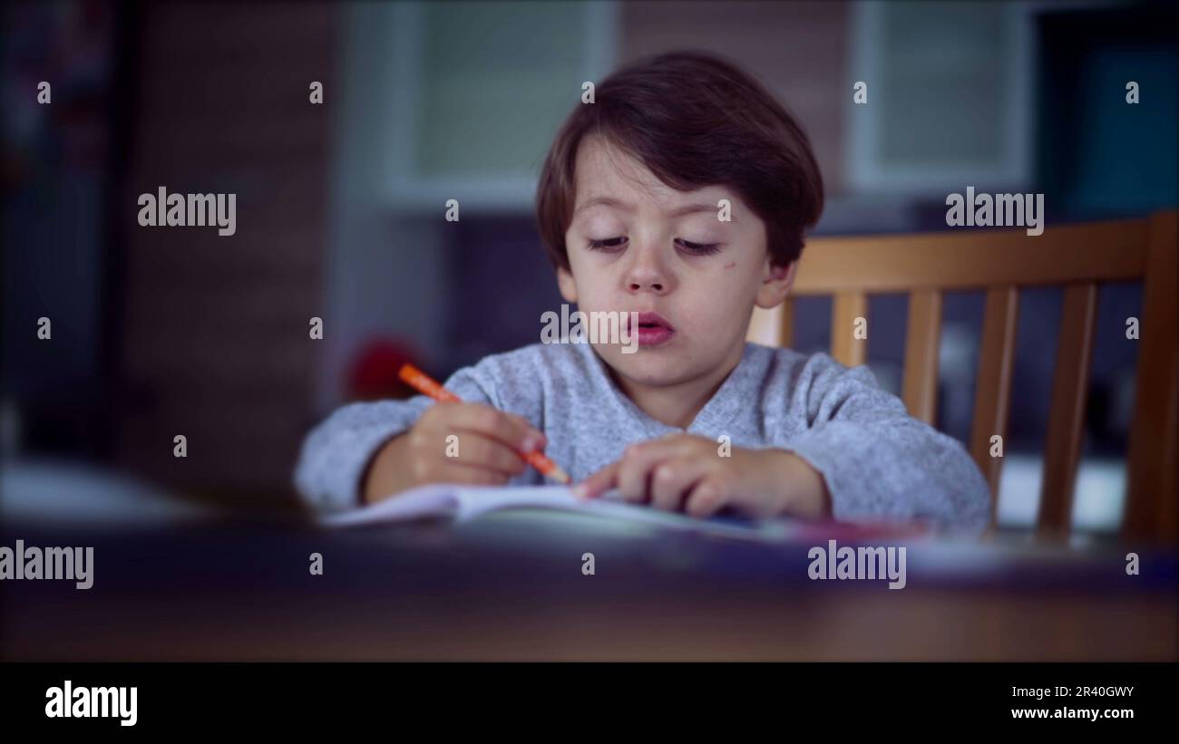Little boy drawing with color pencil. Boy draws a picture at table ...