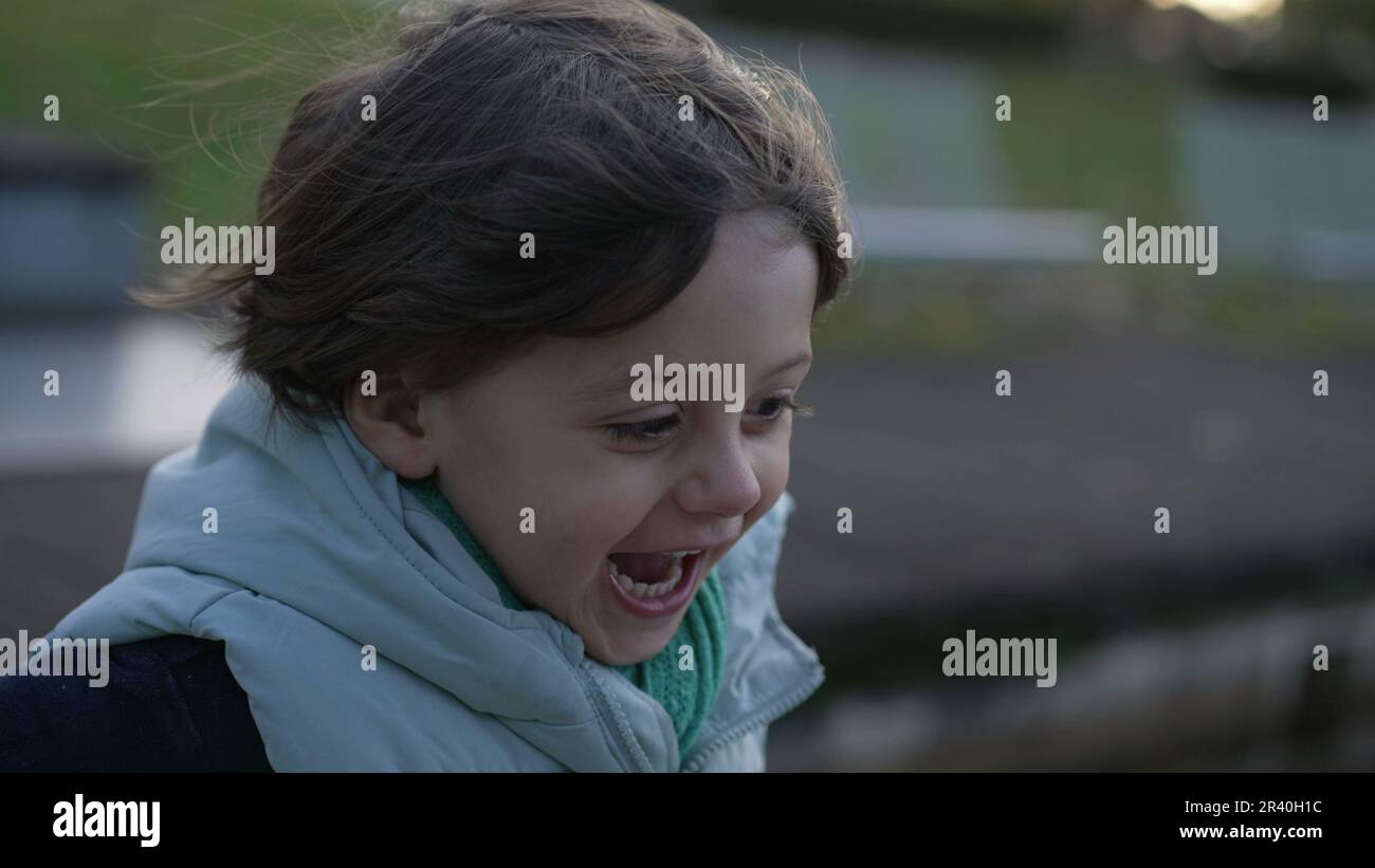 One active little boy runs outside in slow motion in handheld ...