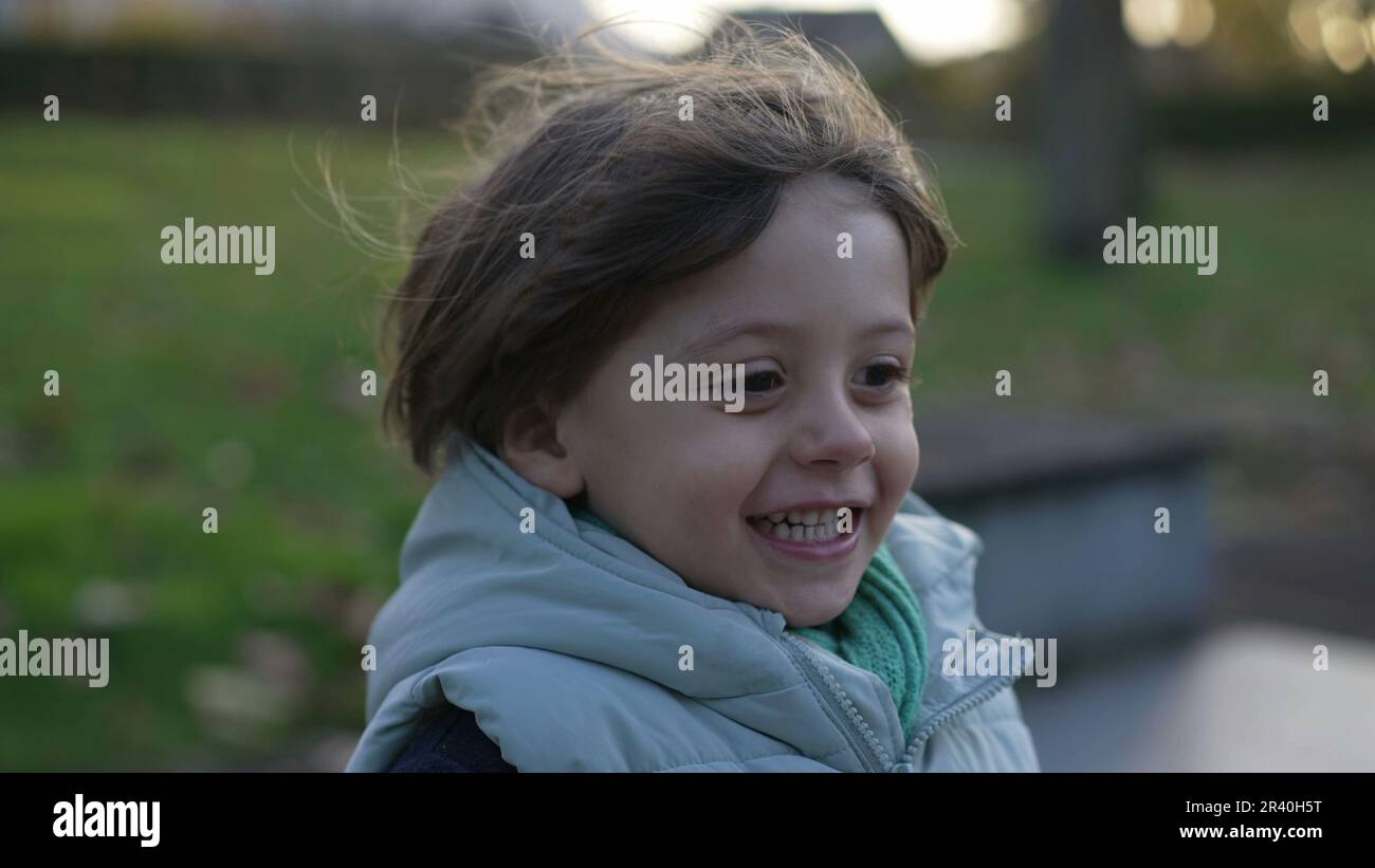 One active little boy runs outside in slow motion in handheld ...
