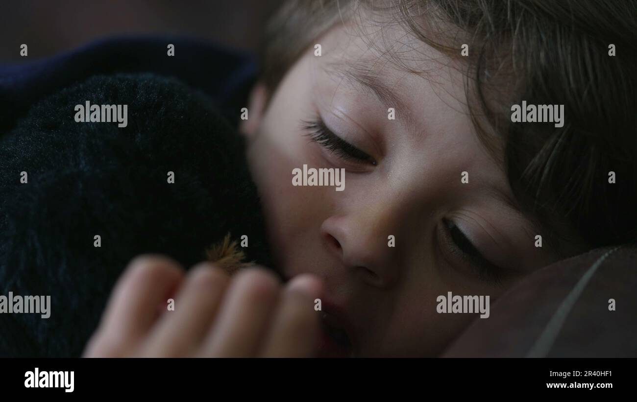 Child nose picking close up face with finger. One thoughtful little boy ...