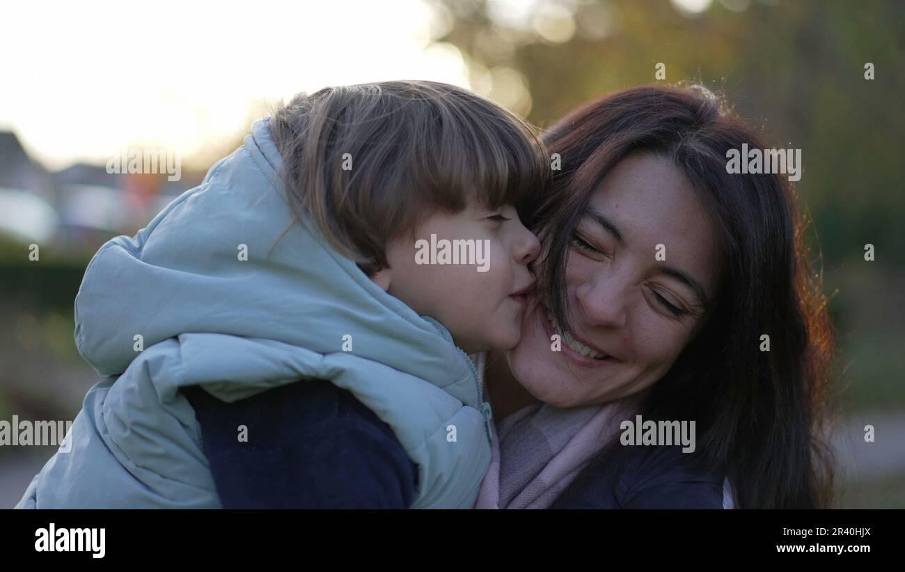 Happy mother and child relationship. Small son kissing mom in cheek ...
