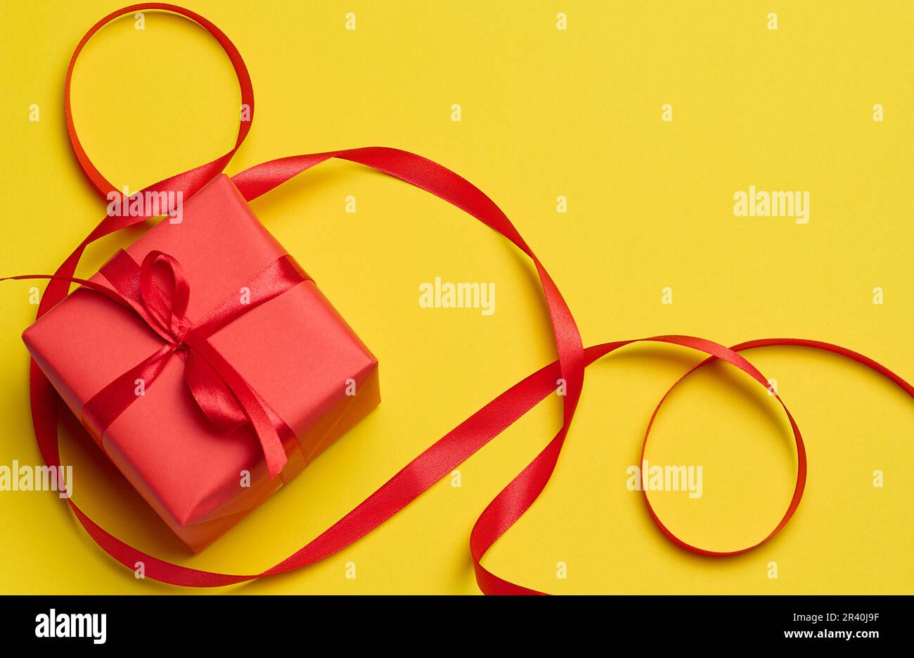Square box tied with a red bow on a yellow background, top view Stock ...