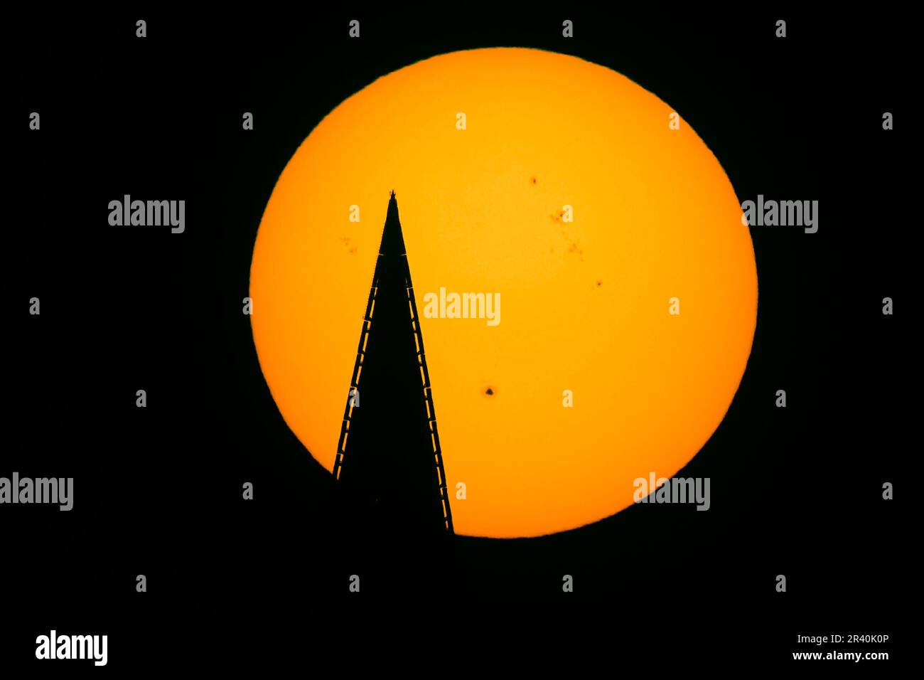 The tip of the Lakhta Center skyscraper is silhouetted against the Sun ...