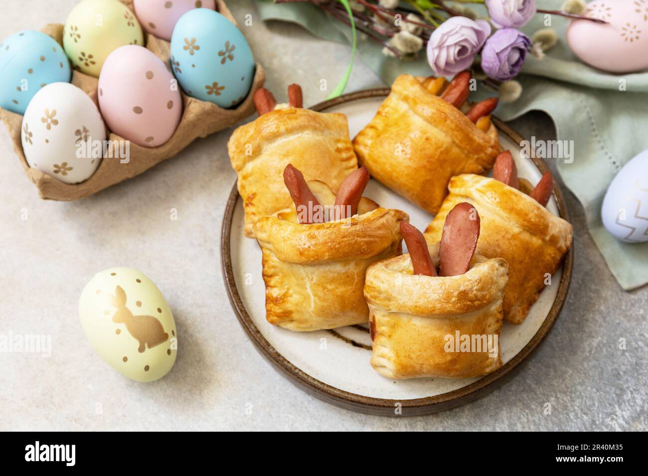 Buns in the form of an Easter rabbit from sausage and cheese in a yeast ...
