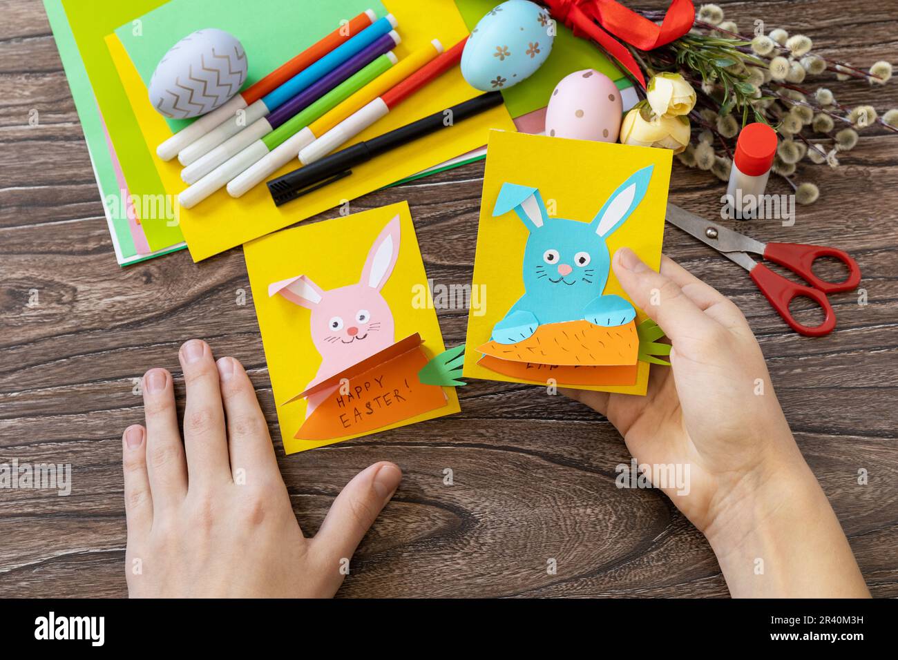 A child is holding an Easter congratulation card with Easter bunny ...