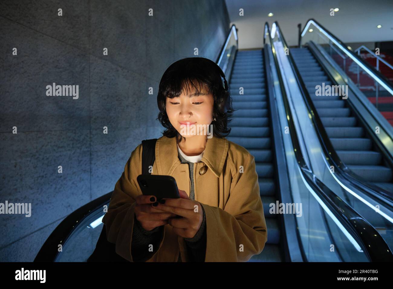 Cute young woman going down the escalator to the tube, using subway ...