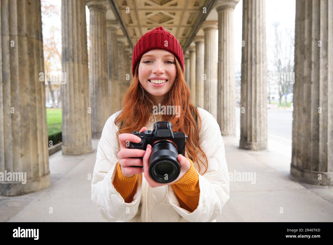 Smiling tourist photographer, takes picture during her trip, holds ...