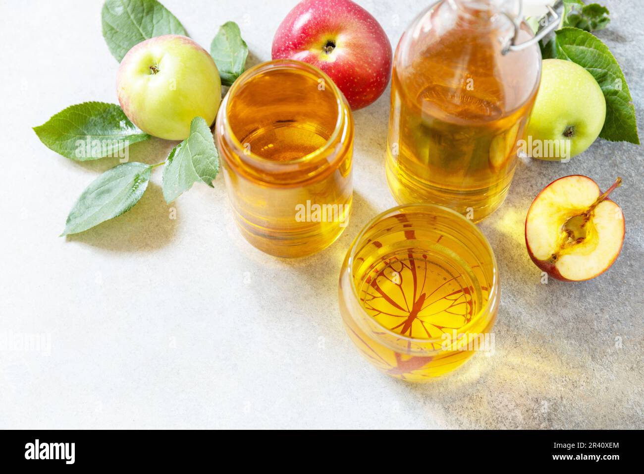 Apple juice in a glass and fresh apples on a stone tabetop. Autumn ...