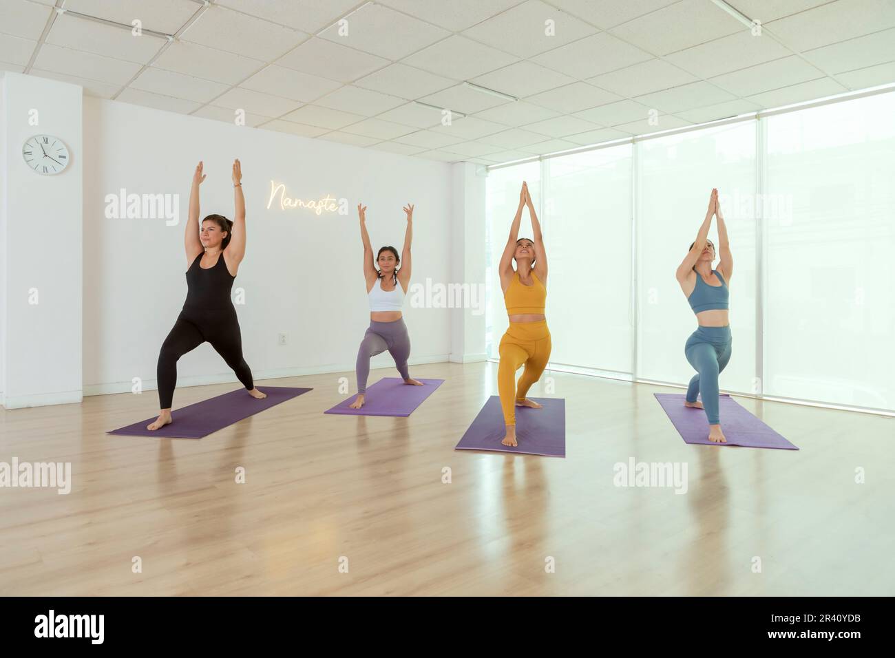 yoga class doing warrior 1 pose inside a yoga studio Stock Photo - Alamy