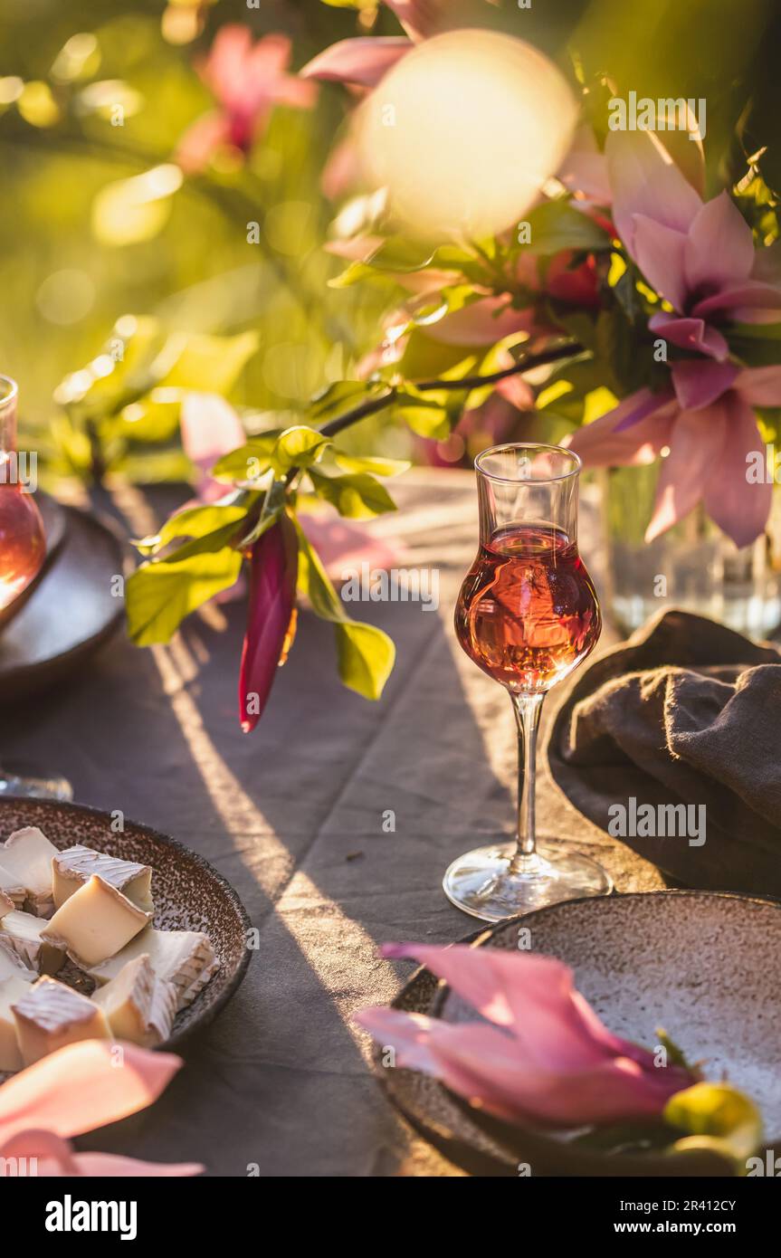 Table Setting in Garden on Sunset Light. Table decorated with magnolia ...