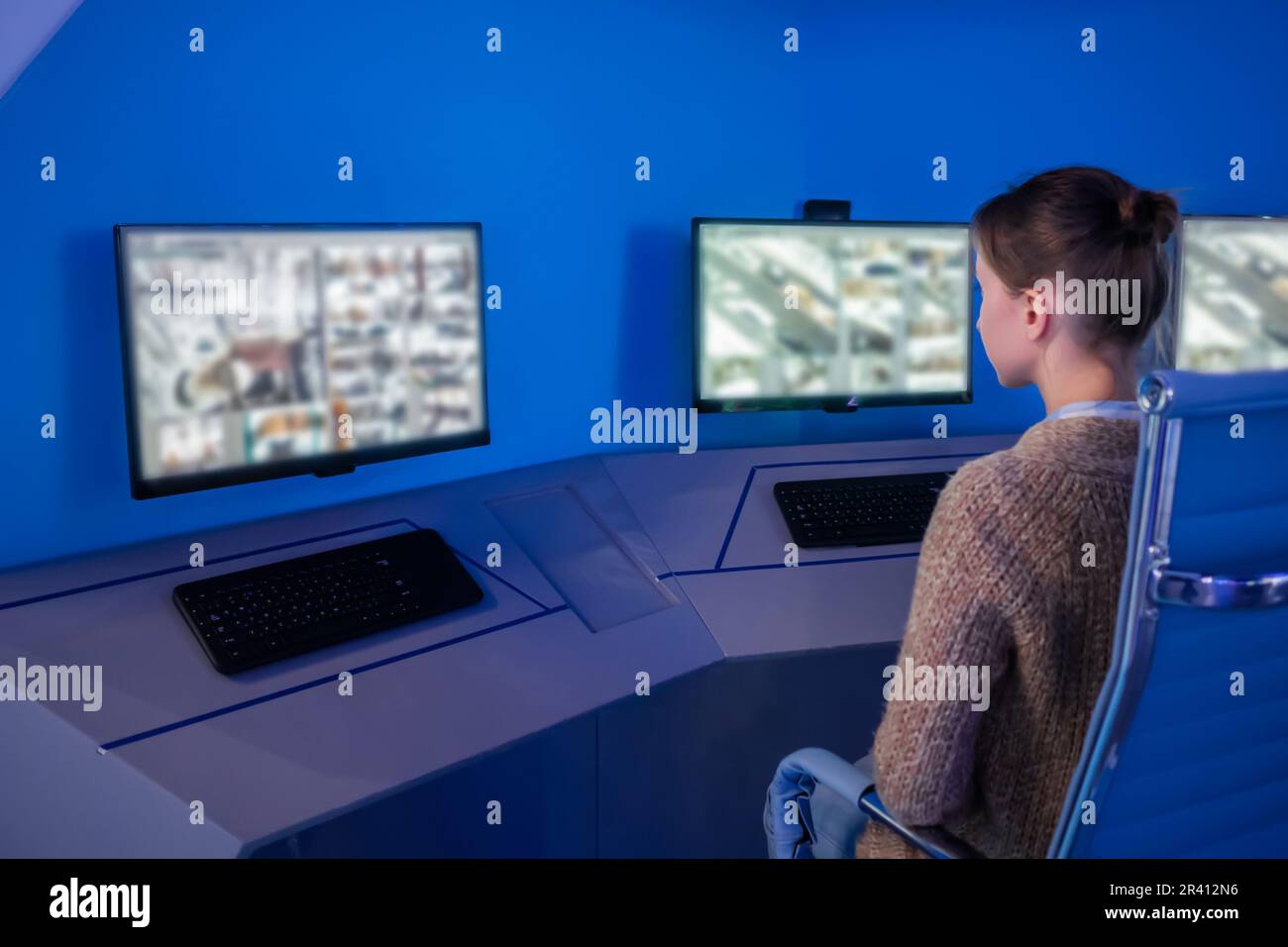 Woman security guard looking at modern cctv camera monitors Stock Photo ...