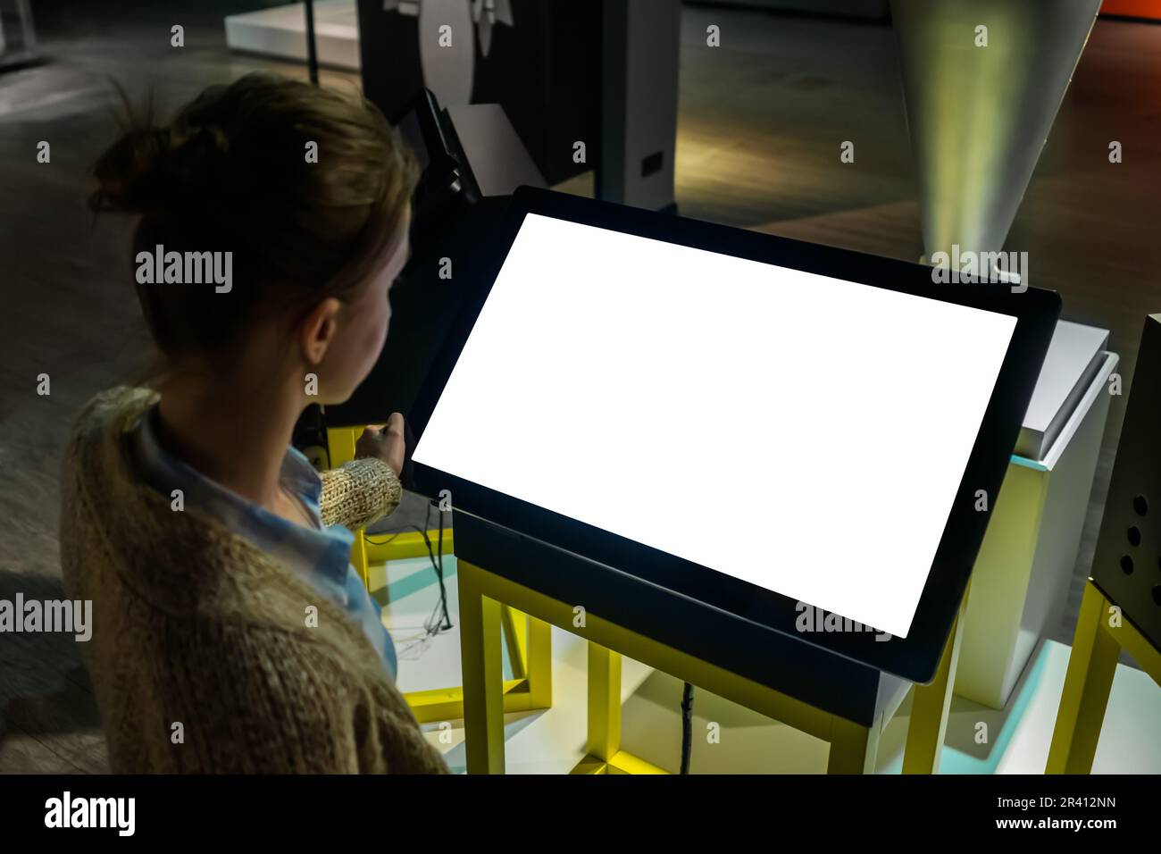 White screen concept - woman looking at blank white display kiosk at ...